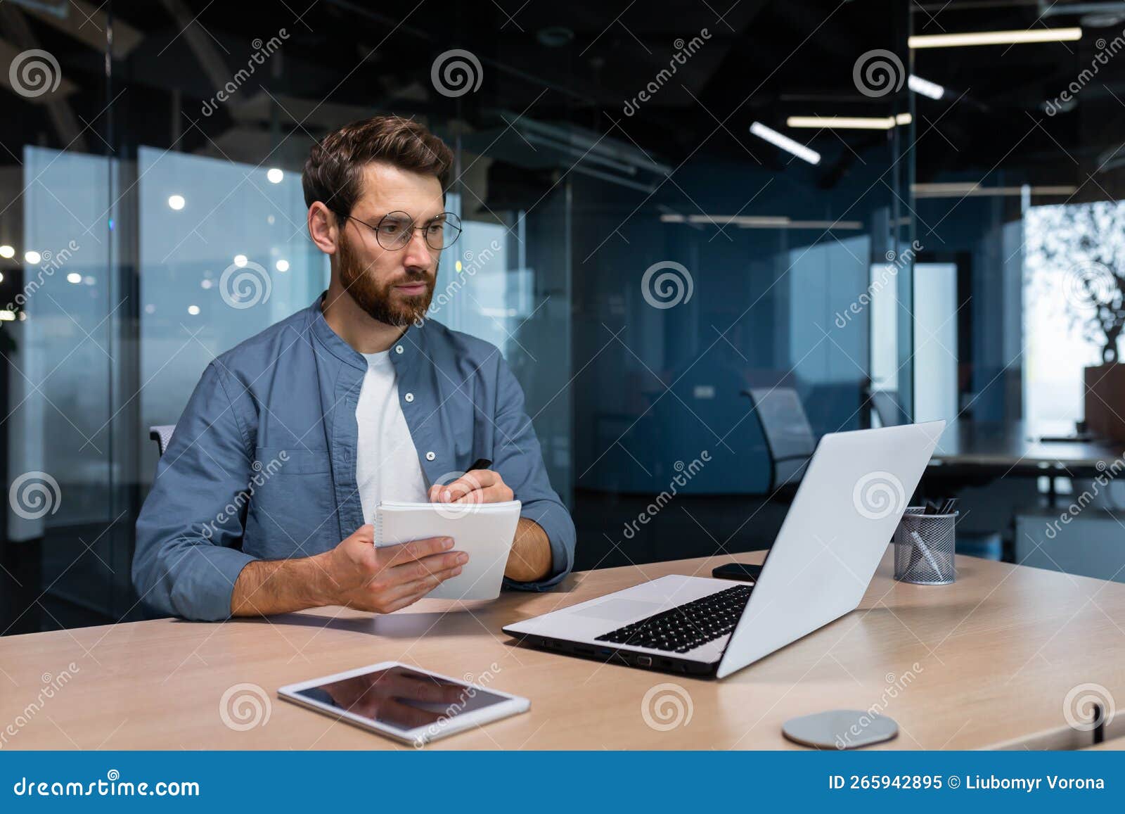 Serious Businessman is Writing Down Information Studying Online while ...