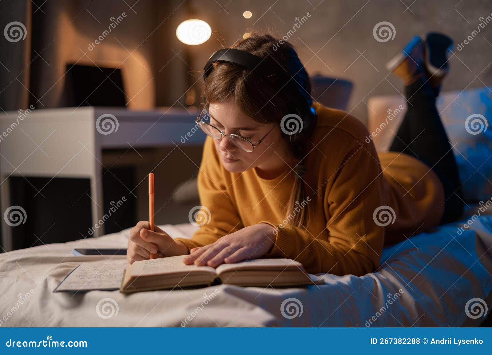 Serious College Student Reading Thick Book and Taking Notes in Textbook ...