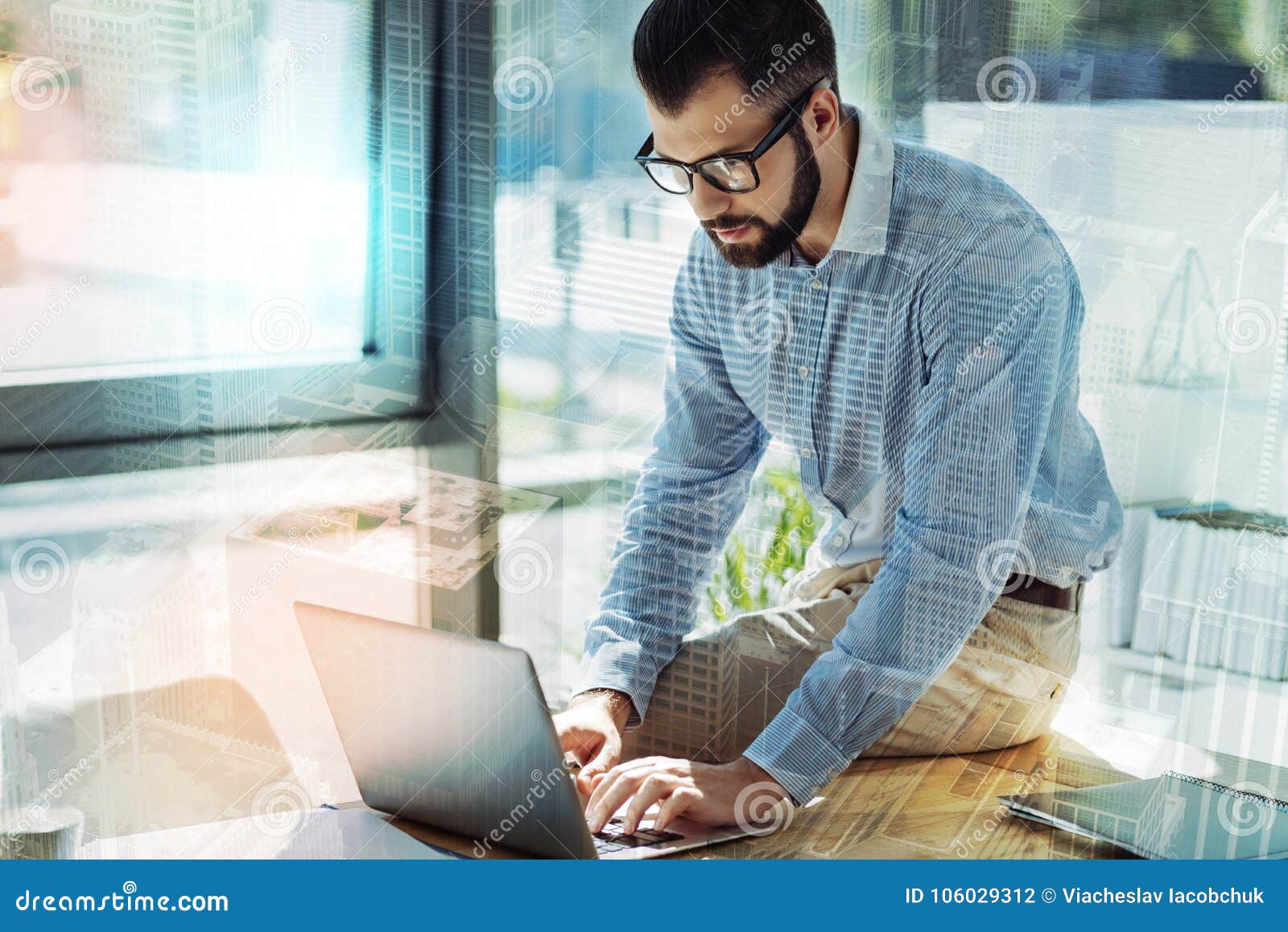 Serious Concentrated Man Sitting on the Table and Using Laptop. Stock ...