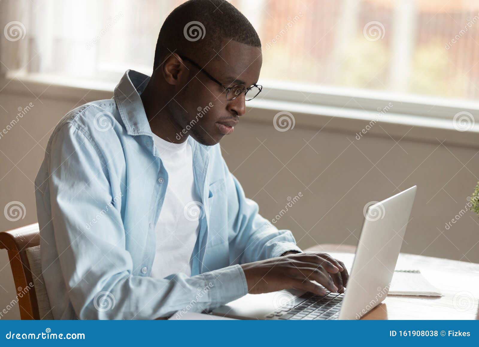 Serious Concentrated Young African American Man Working Remotely with ... Serious Concentrated Young African American Man Working Remotely with ...