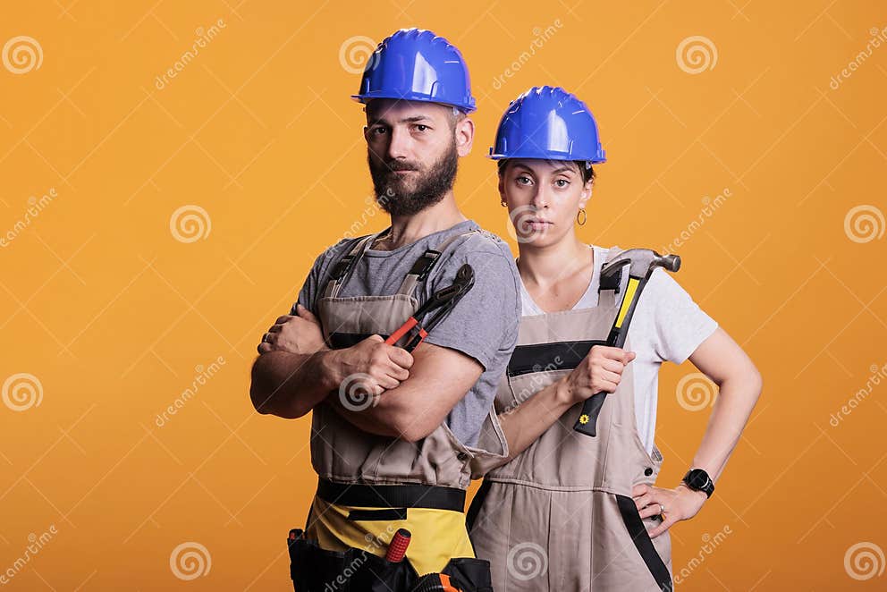 Serious Construction Workers Posing with Pair of Pliers and Hammer ...