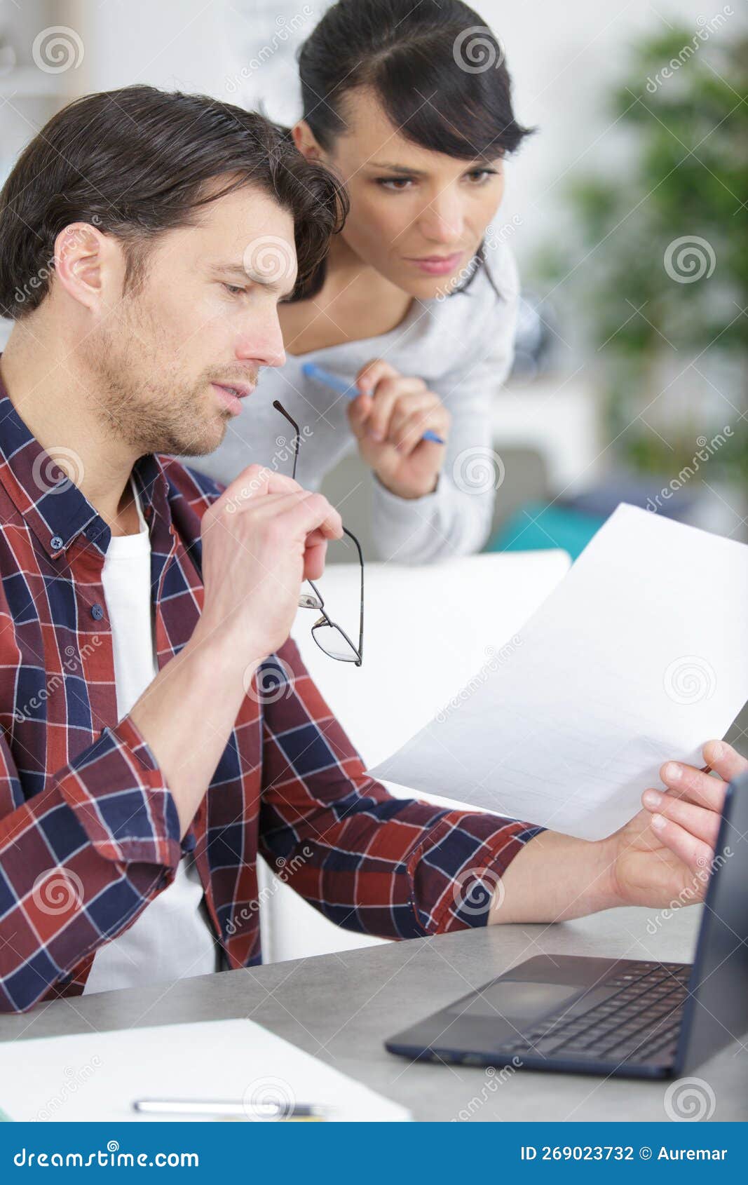 Serious Couple with Laptop Looking at Paperwork Stock Photo - Image of ...