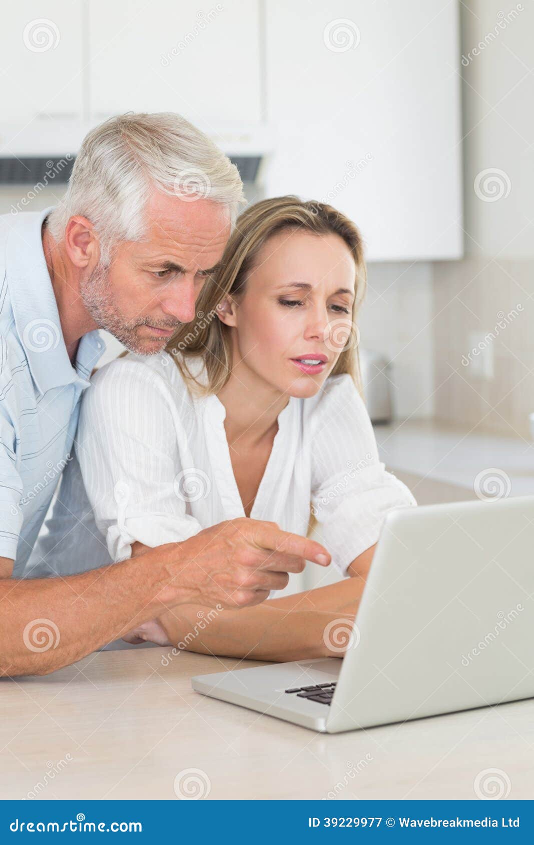 Serious Couple Using Laptop Together At The Counter Stock Image Image