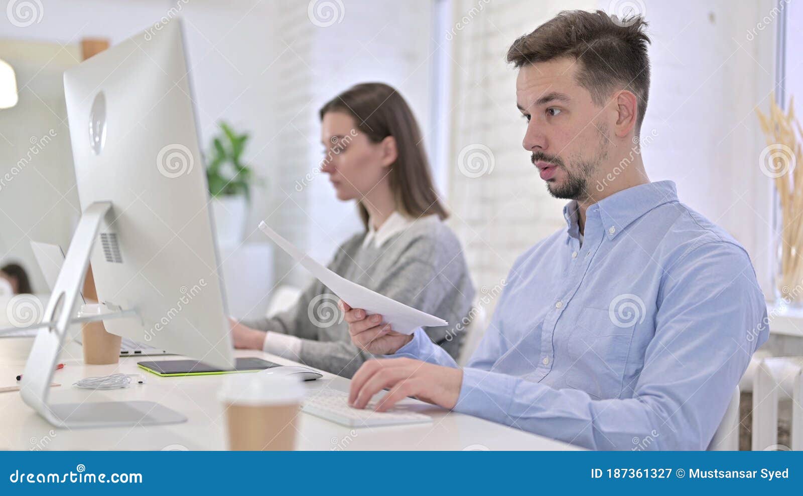 Serious Creative Man Doing Paperwork and Using Desktop Stock Image ...