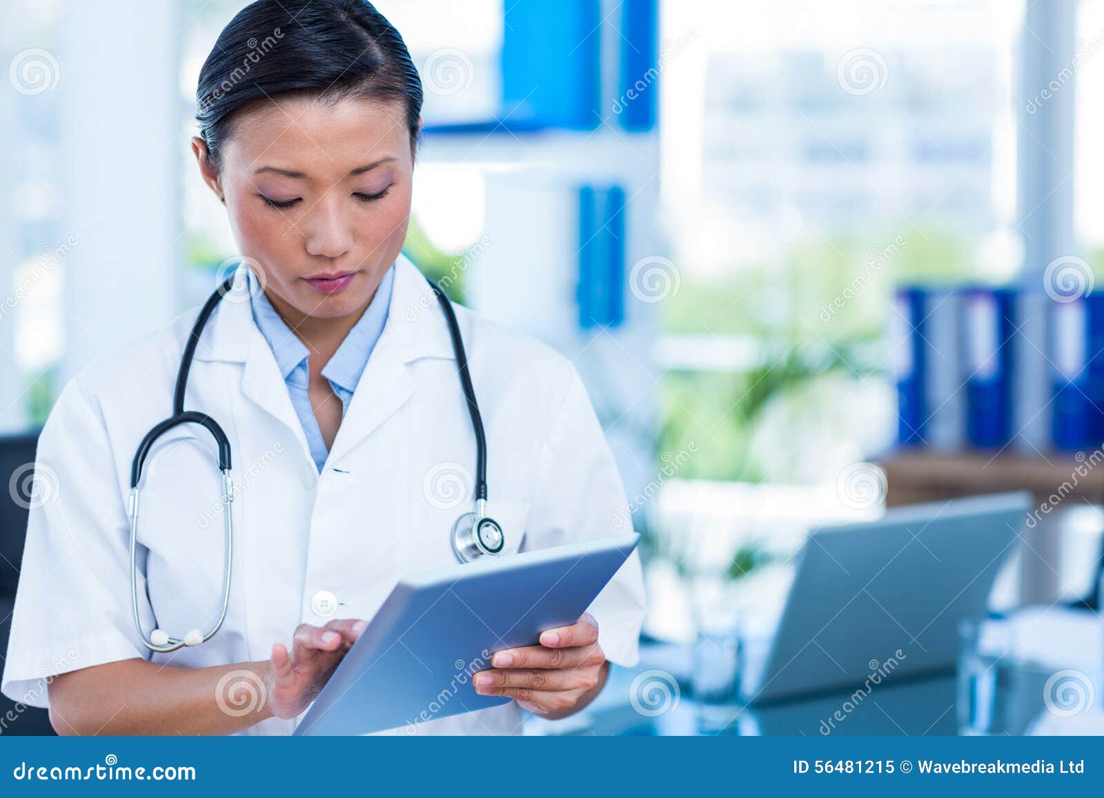 Serious Doctor Using Tablet Stock Image - Image of indoors, coat: 56481215