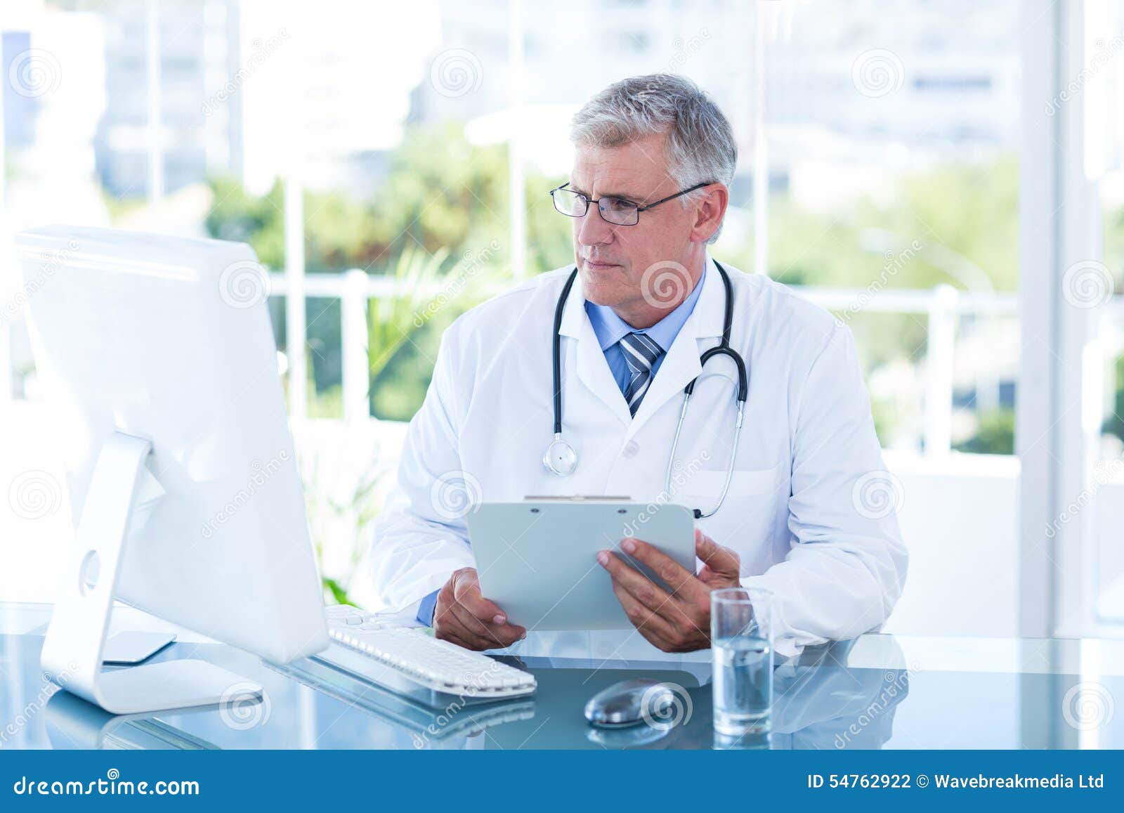 Serious Doctor Working on Computer at His Desk Stock Photo - Image of ...