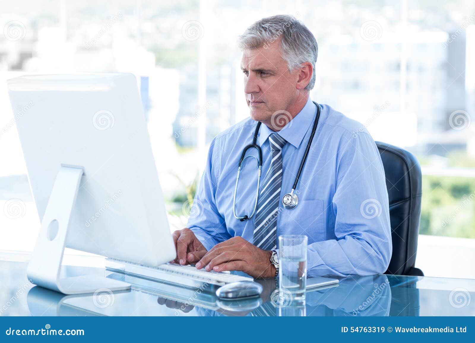 Serious Doctor Working on Computer at His Desk Stock Image - Image of ...