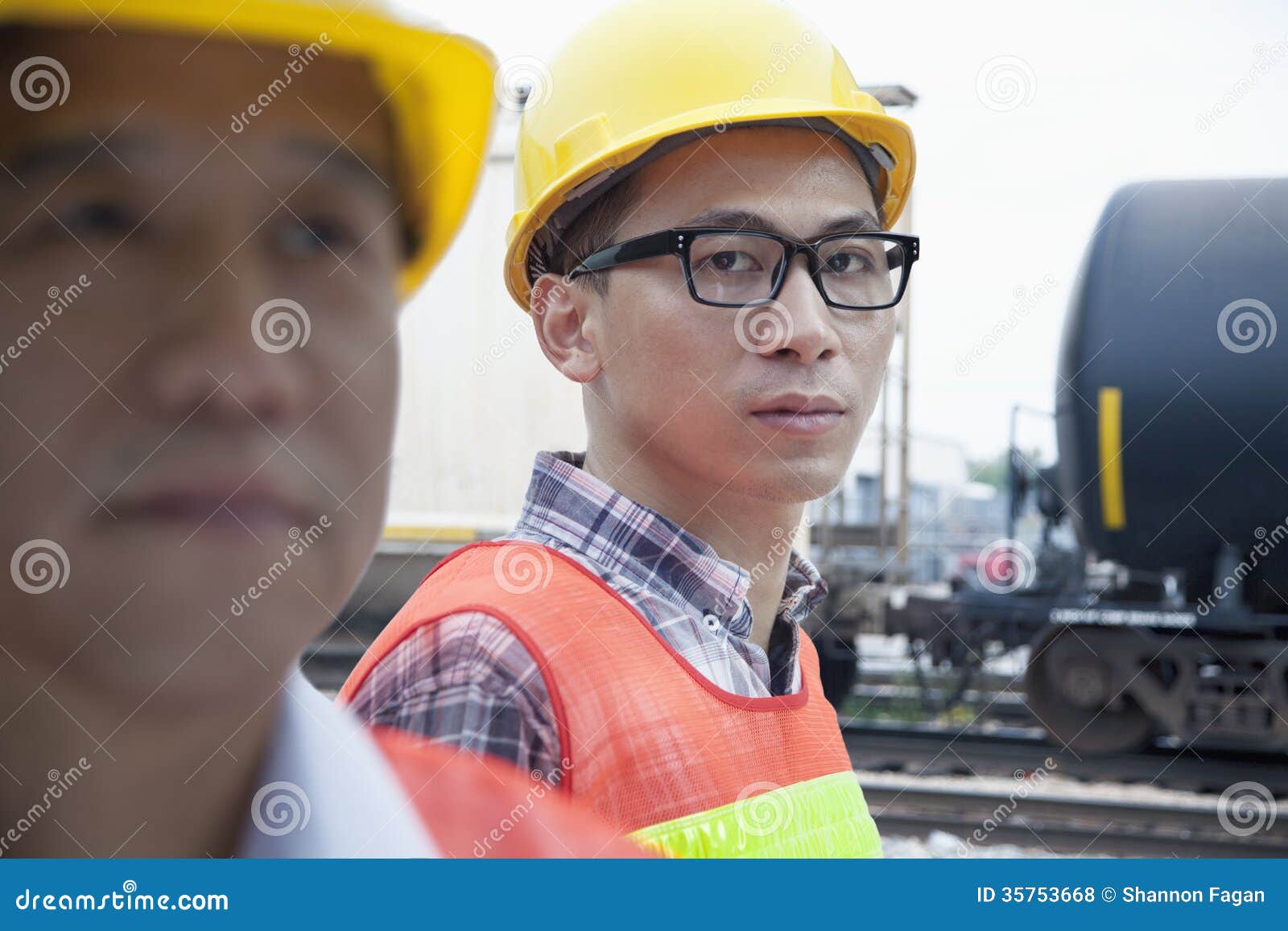 Serious Engineer In Hard Hat Confidently Looks At Camera Holding ...