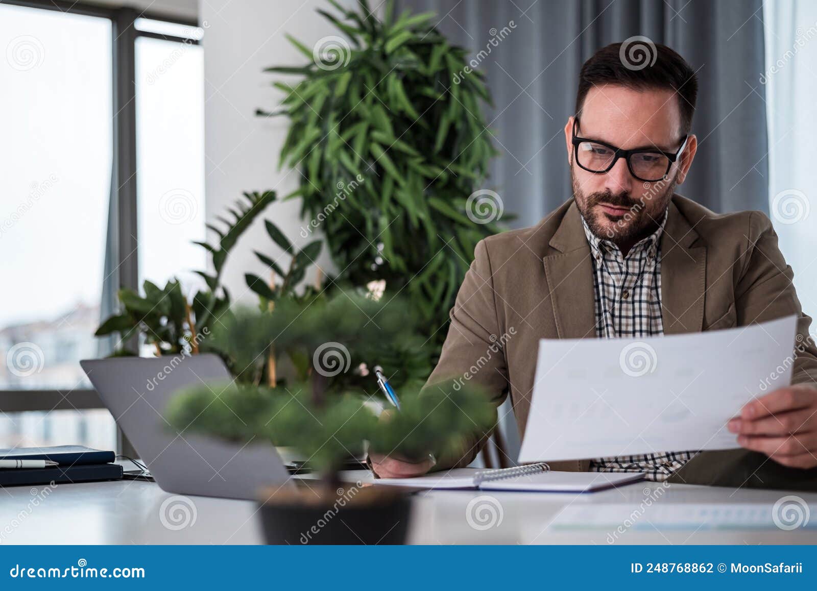 Serious Executive Analyzing Documents while Planning Business Strategy ...