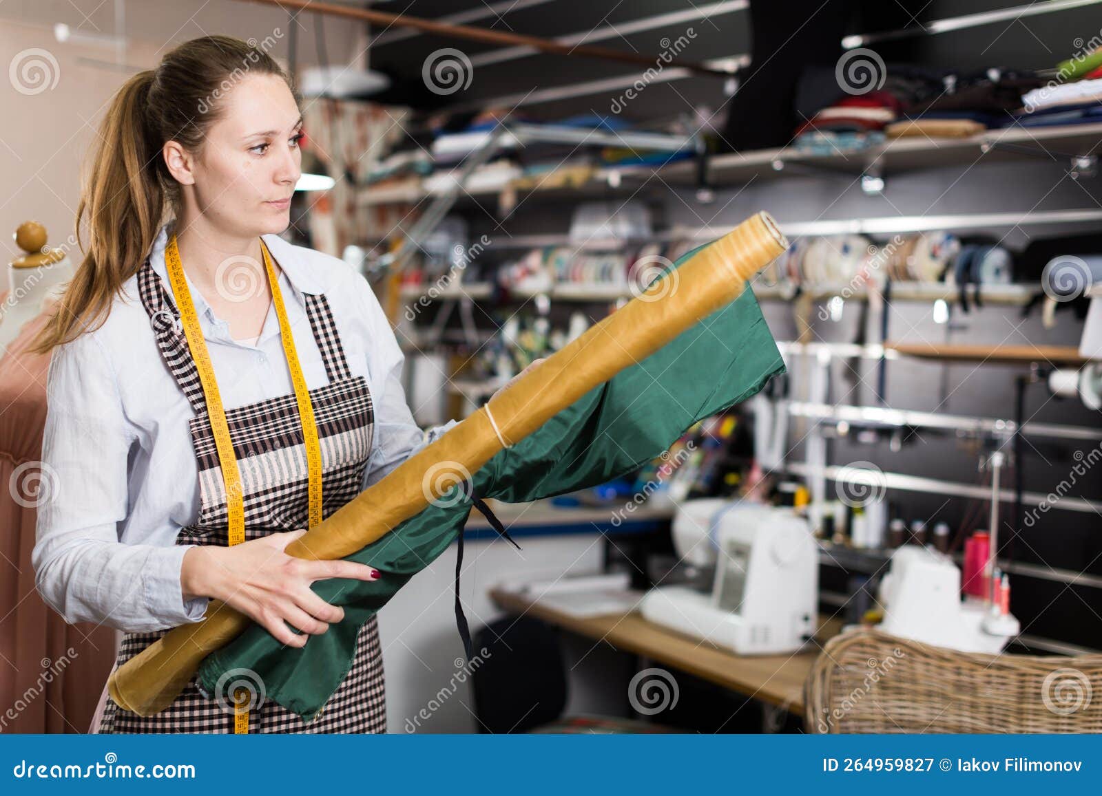 Serious Female Professional Sewer Holding Tubes with Material Stock ...