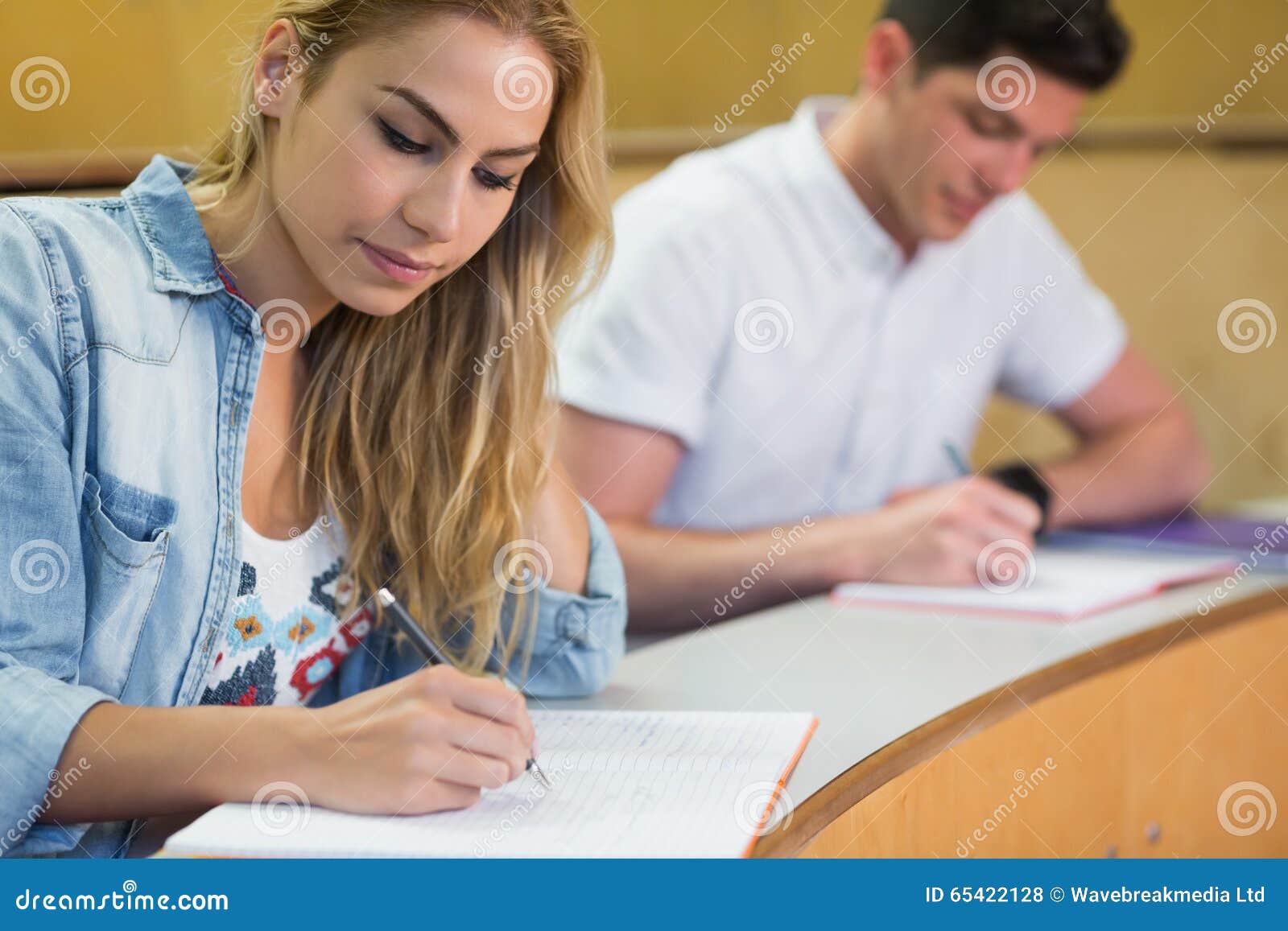 Serious Female Student Writing during Class Stock Photo - Image of book ...