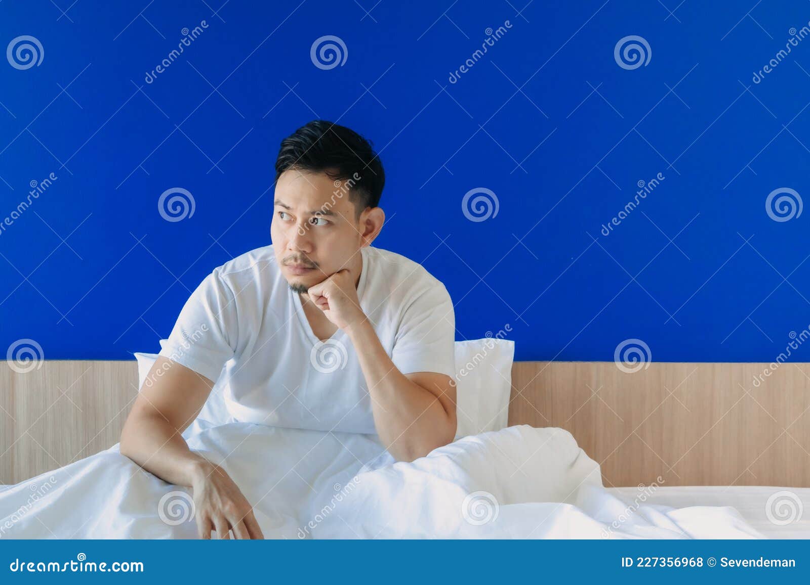 Serious And Grumpy Man Wake Up On The Bed On Blue Space Background ...