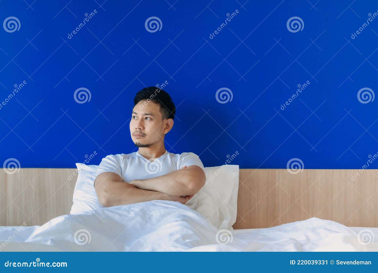 Serious and Grumpy Man Wake Up on the Bed on Blue Space Background ...