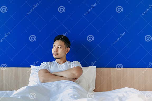 Serious and Grumpy Man Wake Up on the Bed on Blue Space Background ...