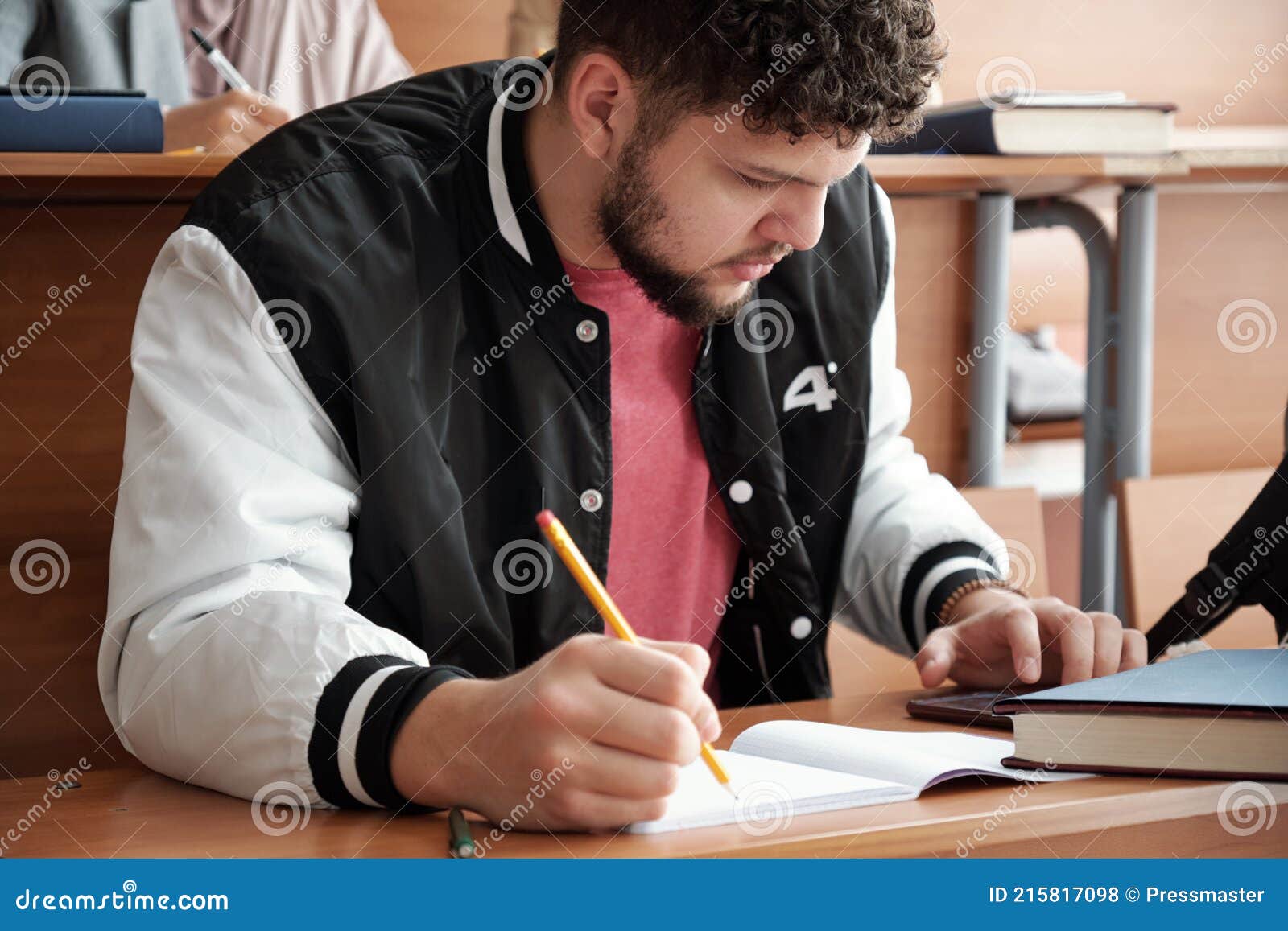 Serious Guy in Casualwear Bending Over Desk and Making Notes in ...