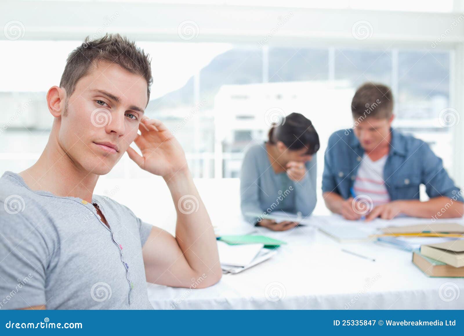 A Serious Looking Student with His Hand on His Head Looks into T Stock ...