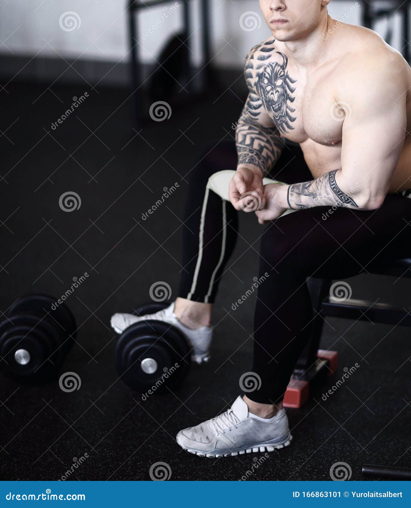 Male Bodybuilder Sitting on a Bench in the Gym. Stock Image - Image of ...
