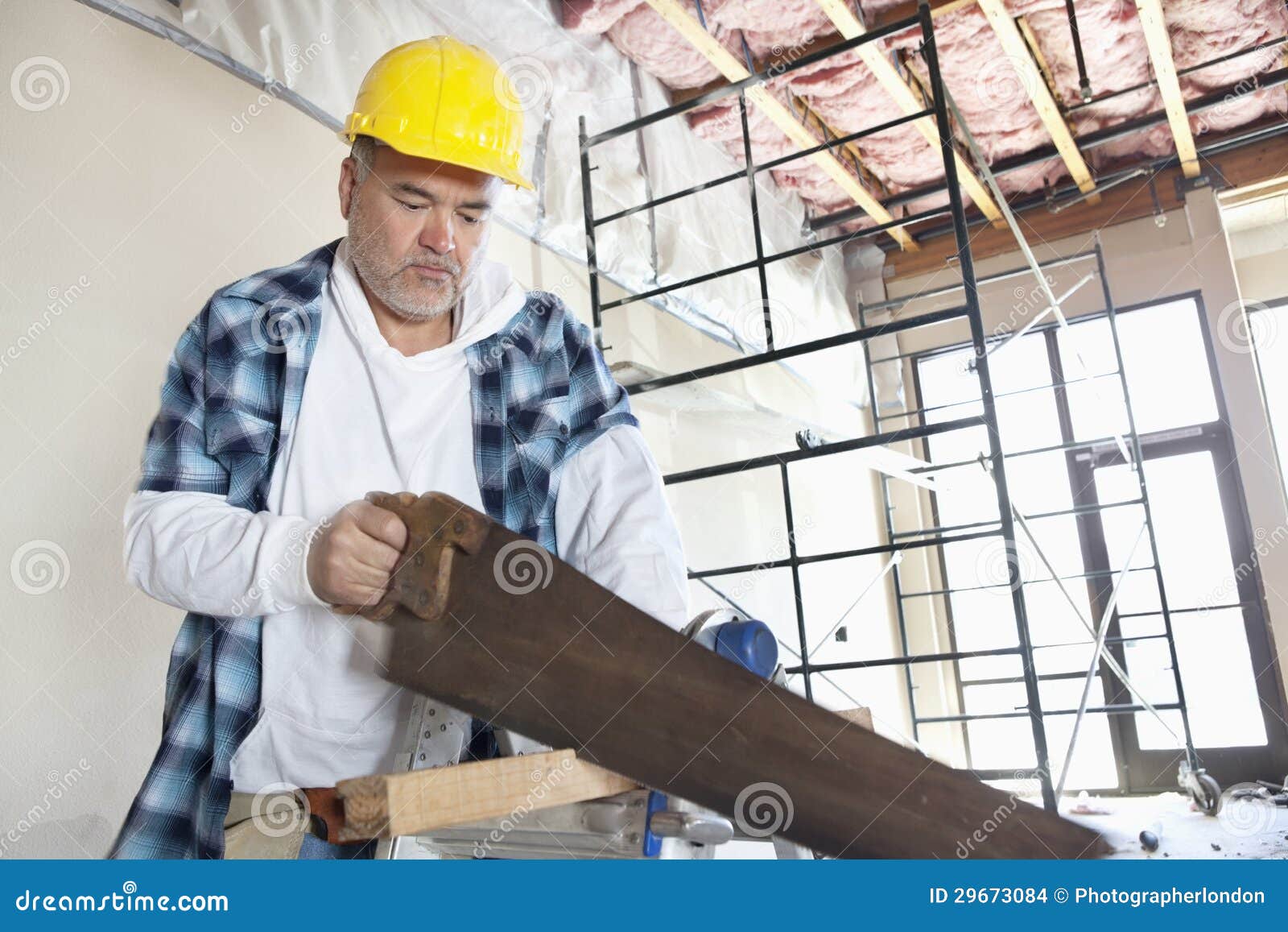 Serious Male Construction Worker Cutting Wood with Handsaw Stock Photo ...