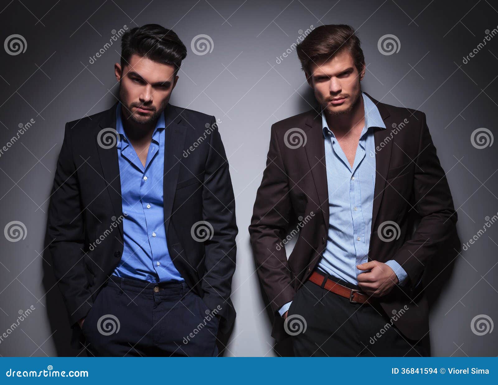 Serious Male Models Posing Against Gray Wall Stock Photo - Image of ...