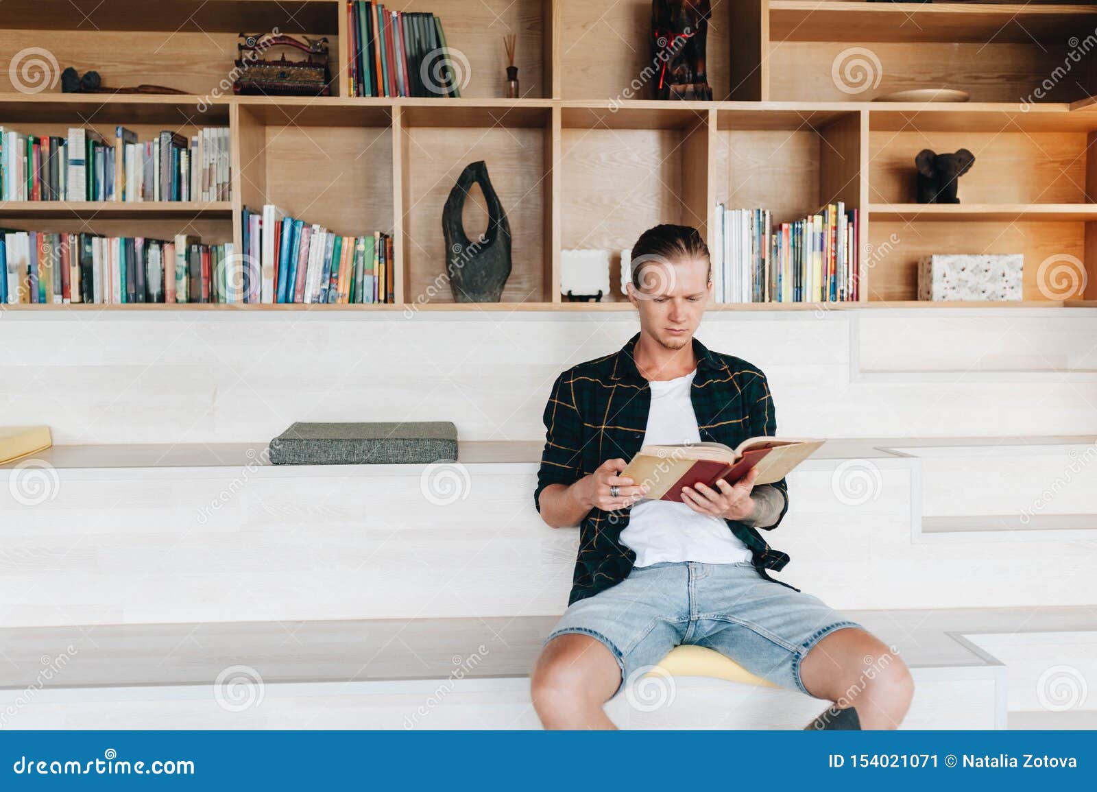 Serious Male Student Reading a Book in a Library Stock Image - Image of ...
