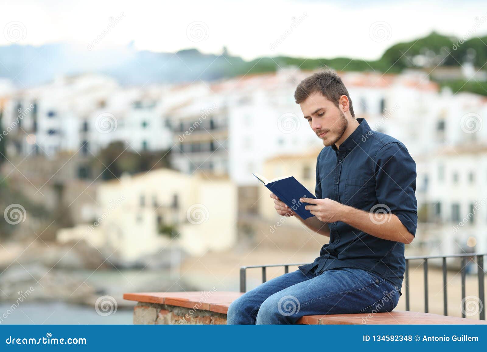 Serious Man Reading a Paper Book in a Coast Town Stock Photo - Image of ...