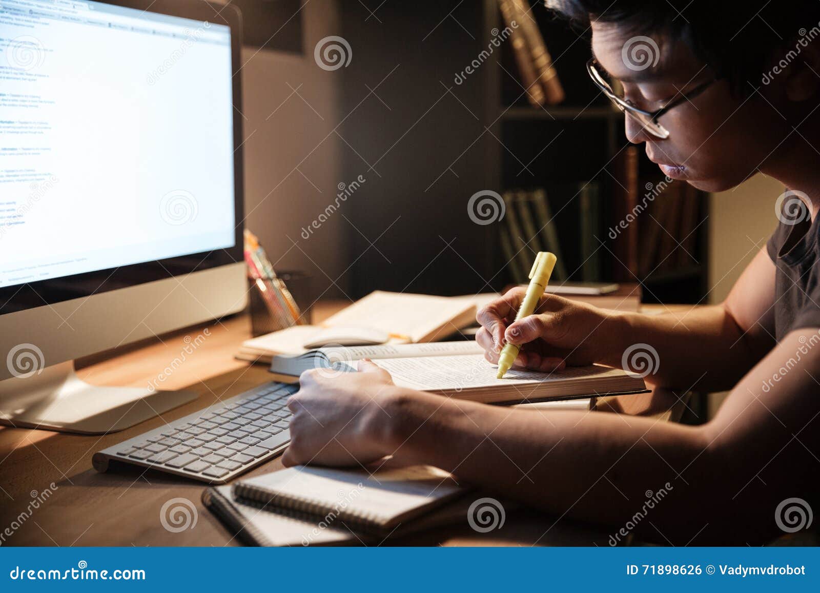 Serious Man Studying with Books and Computer in Dark Room Stock Photo ...