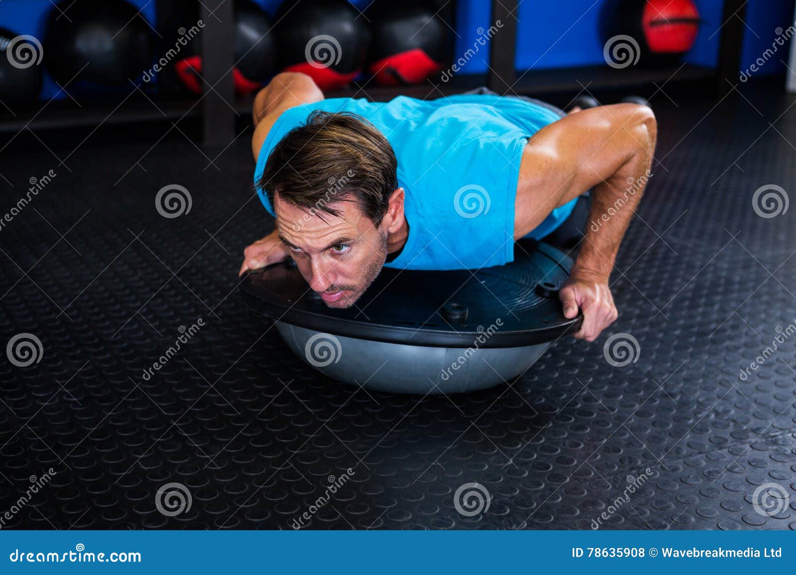 Serious Man Using BOSU Ball in Gym Stock Photo - Image of looking ...