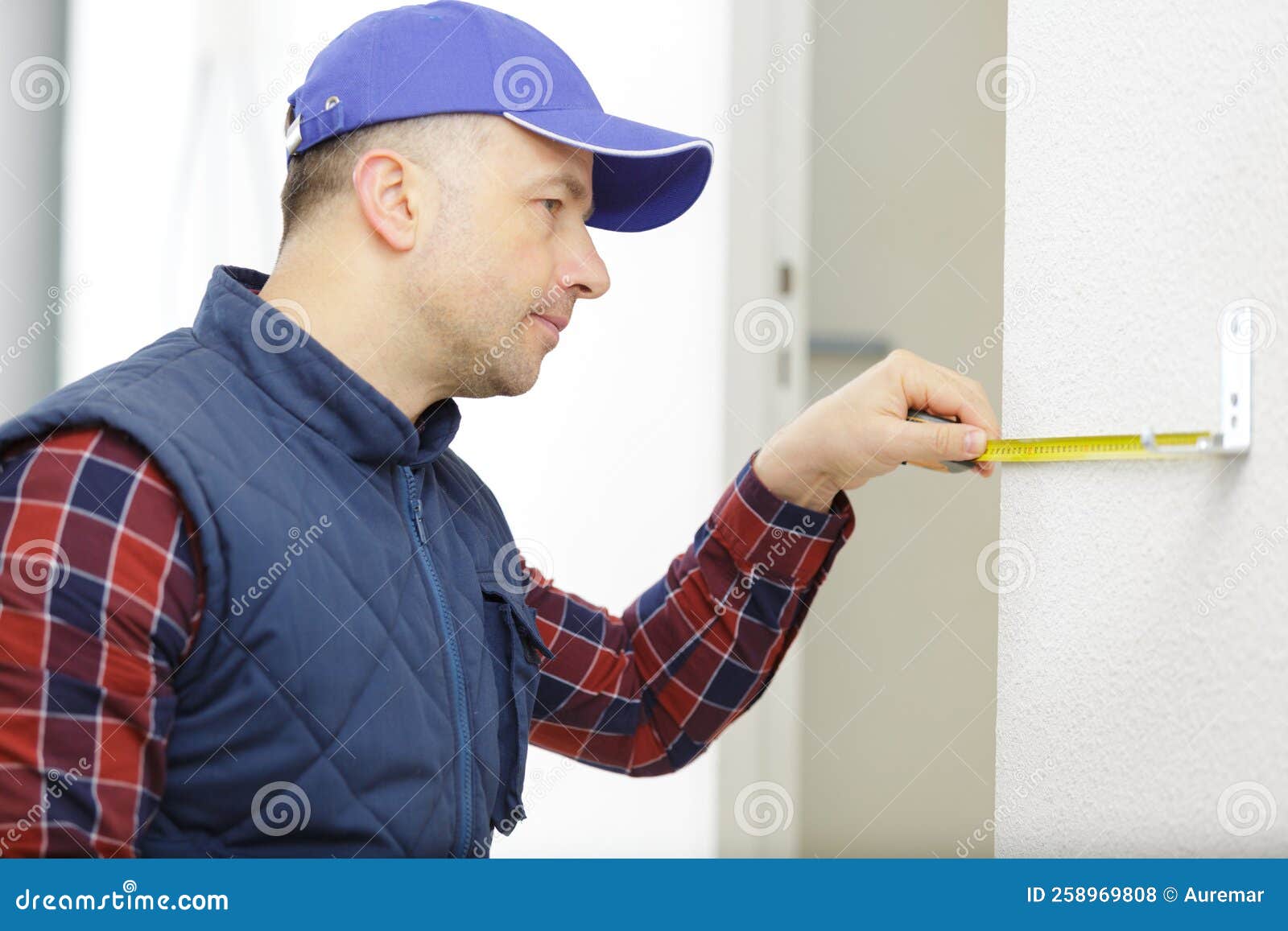 Serious Man Using Measuring Tape on White Wall Stock Photo - Image of ...