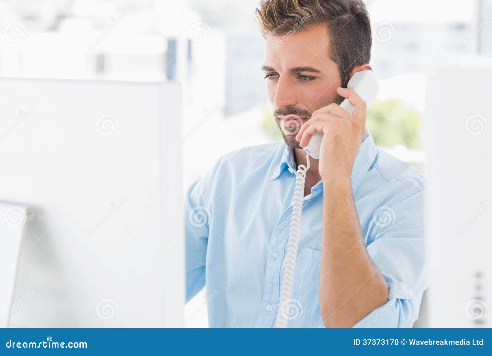 Serious Man Using Phone and Computer in Office Stock Photo - Image of ...