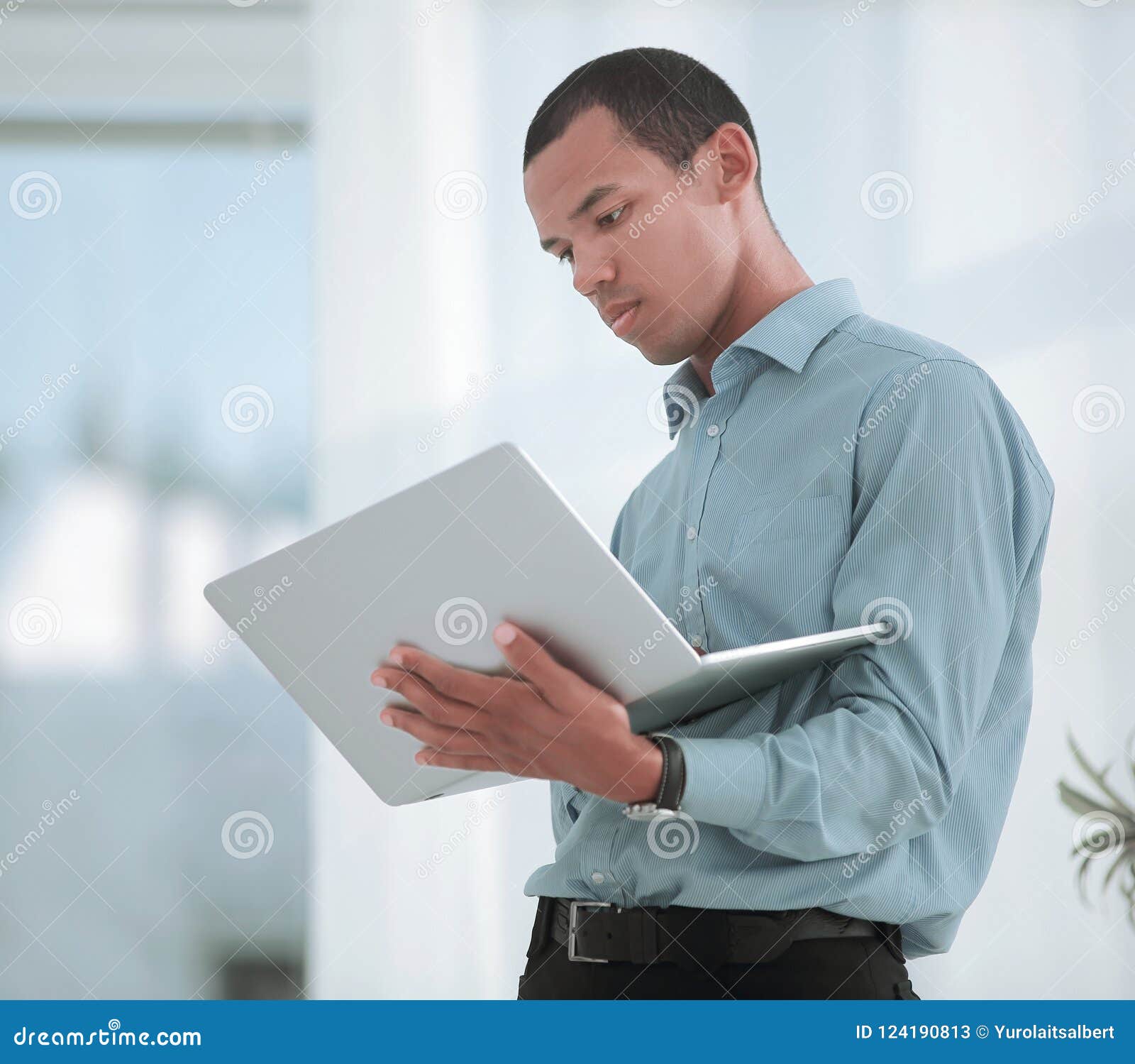 Serious Manager Working on a Laptop Standing in Office Stock Image ...