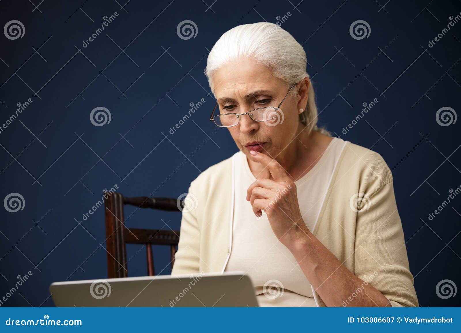 Serious Old Woman Using Laptop Computer. Looking Aside. Stock Image ...