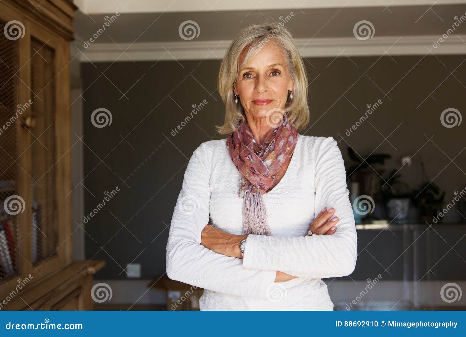 Serious Older Woman Standing in Study with Arms Crossed Stock Photo ... Serious Older Woman Standing in Study with Arms Crossed Stock Photo ...