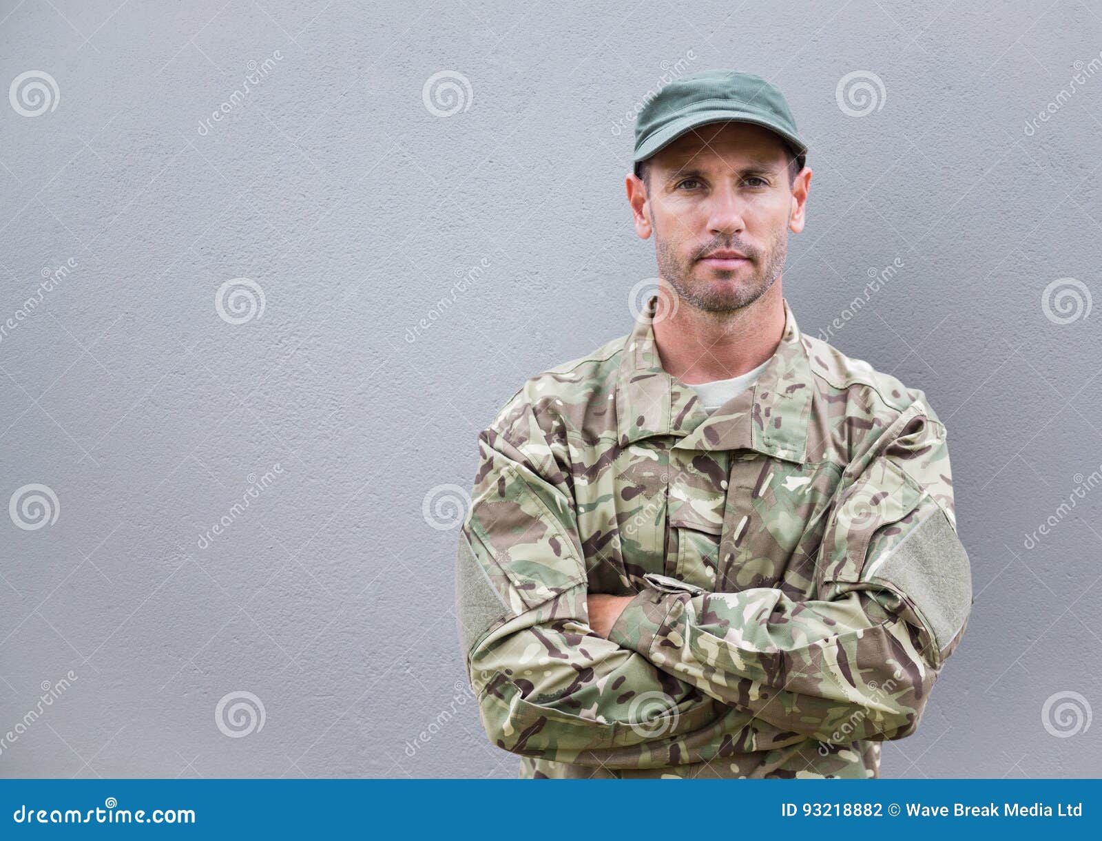 Serious Soldier with His Hands Folded. Concrete Wall Behind Stock Photo ...