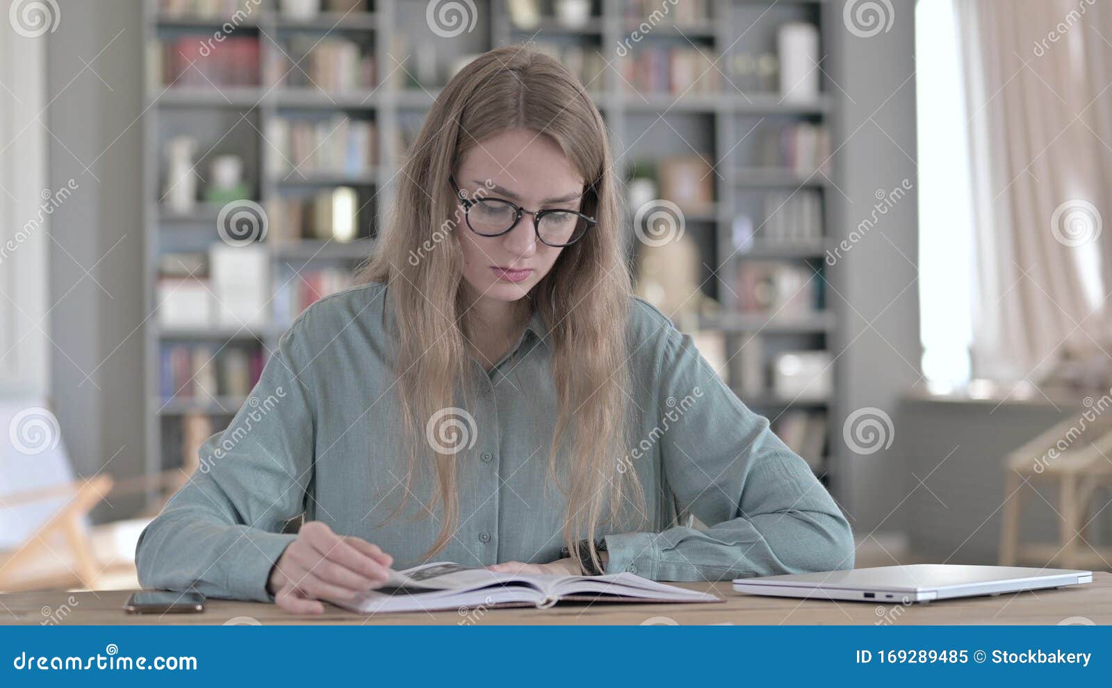 The Serious Student Sitting in Study Room and Reading Book Stock Image ...