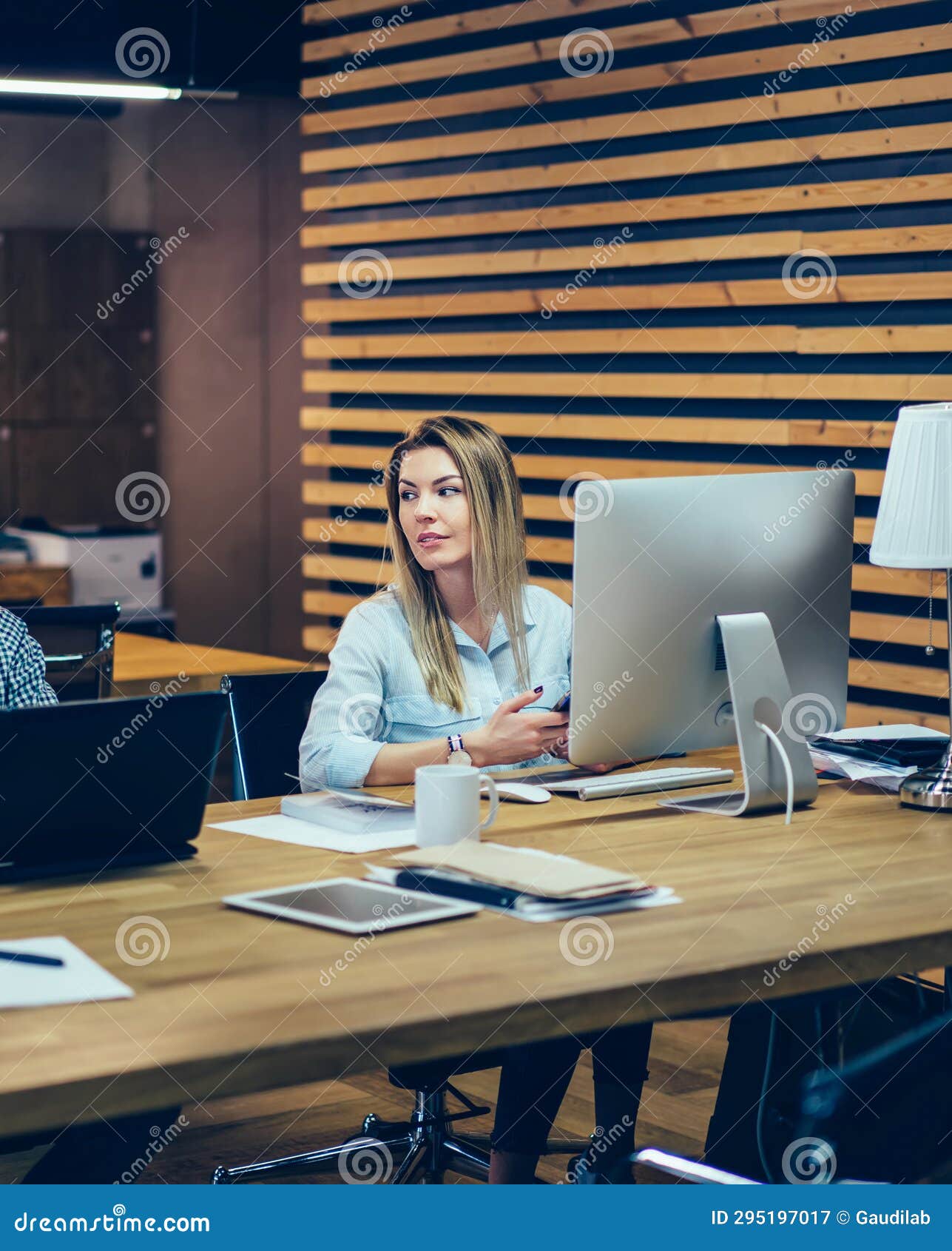 Serious Students Speaking while Working at Laptop and Computer at Table ...