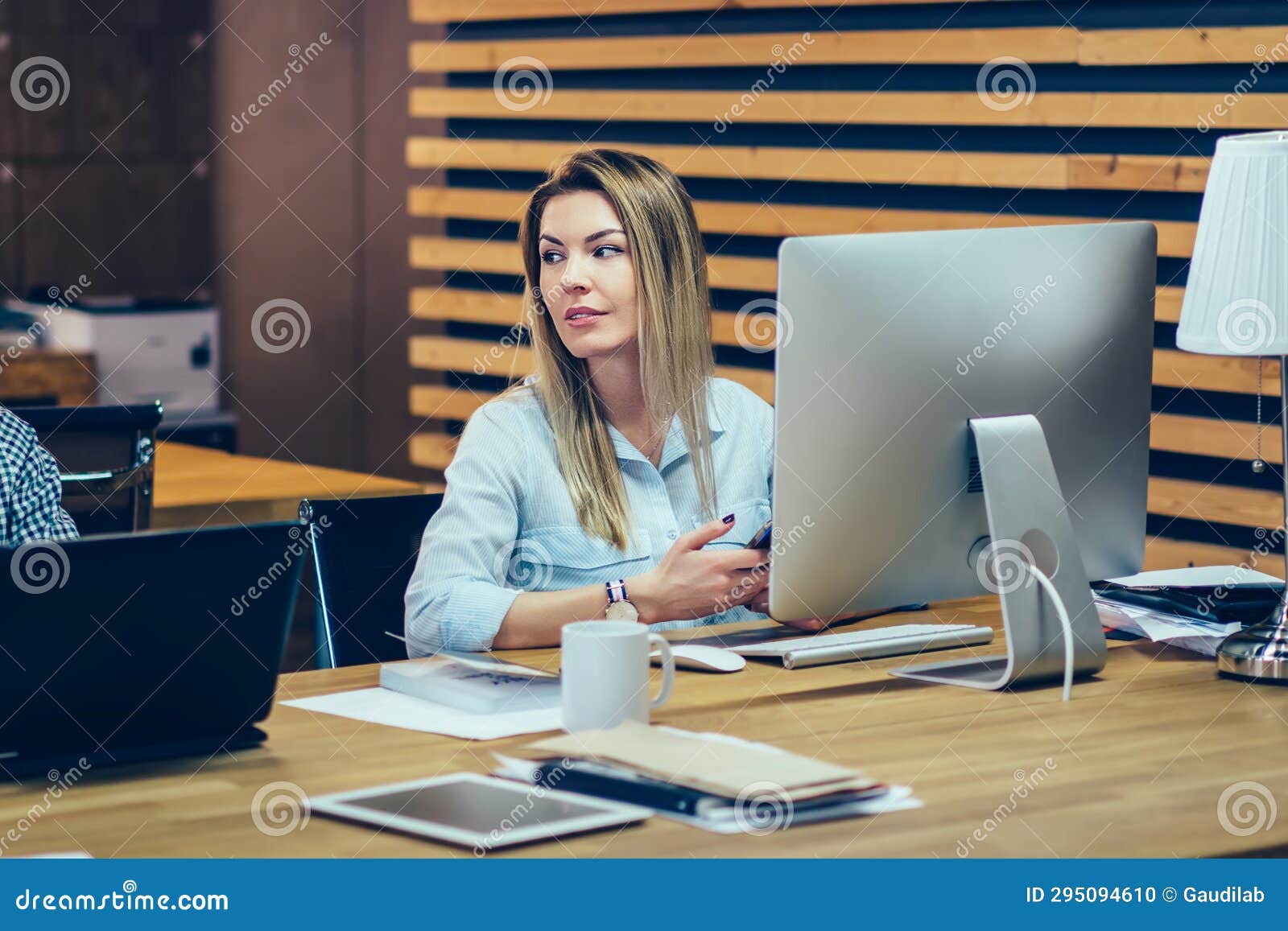Serious Students Speaking while Working at Laptop and Computer at Table ...