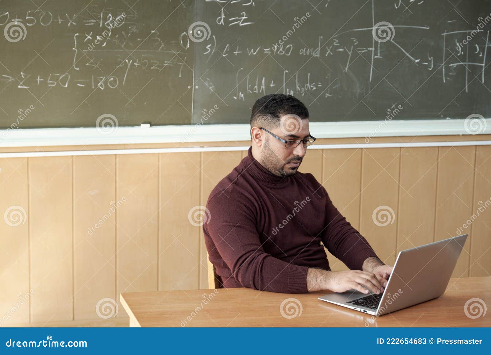 Serious Teacher Typing by Desk in Classroom Stock Image - Image of ...