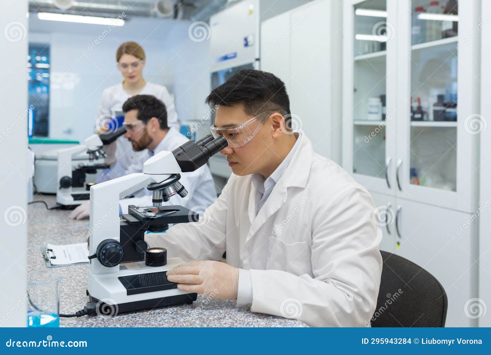Serious Thinking Asian Scientist Working with Microscope Inside ...