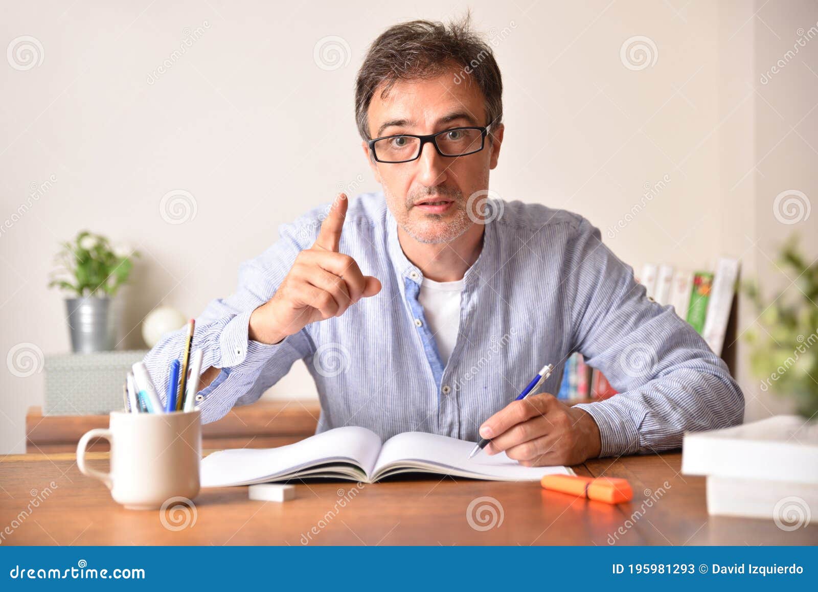 Serious Tutor with Raised Finger Writing in a Book Stock Image - Image ...