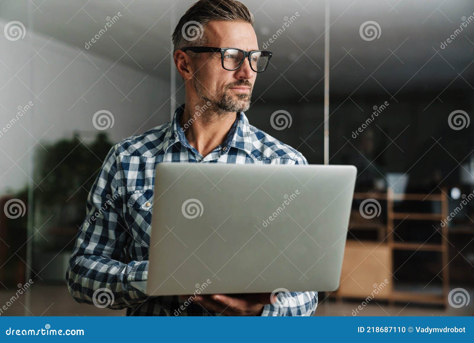 Serious Man Working with Laptop while Standing in Office Stock Photo ...