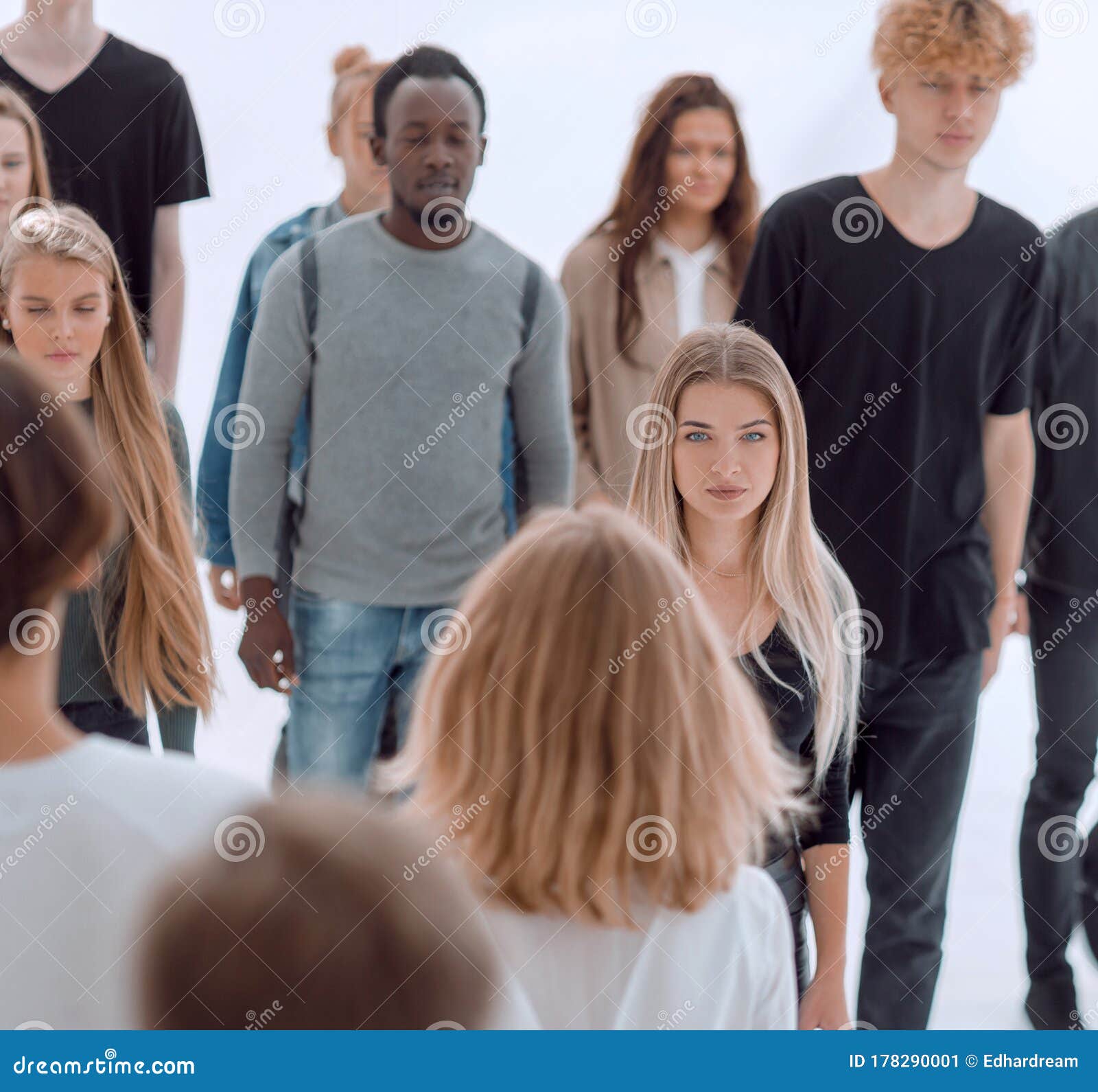 Serious Woman Standing in Front of Casual Group of Young People Stock ...