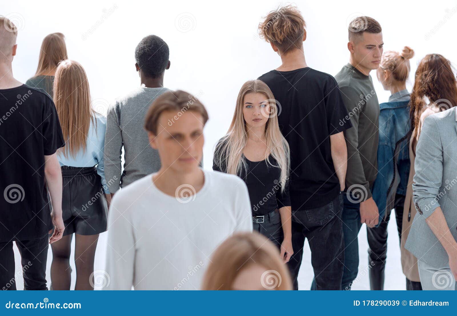 Serious Woman Standing in Front of Casual Group of Young People Stock ...
