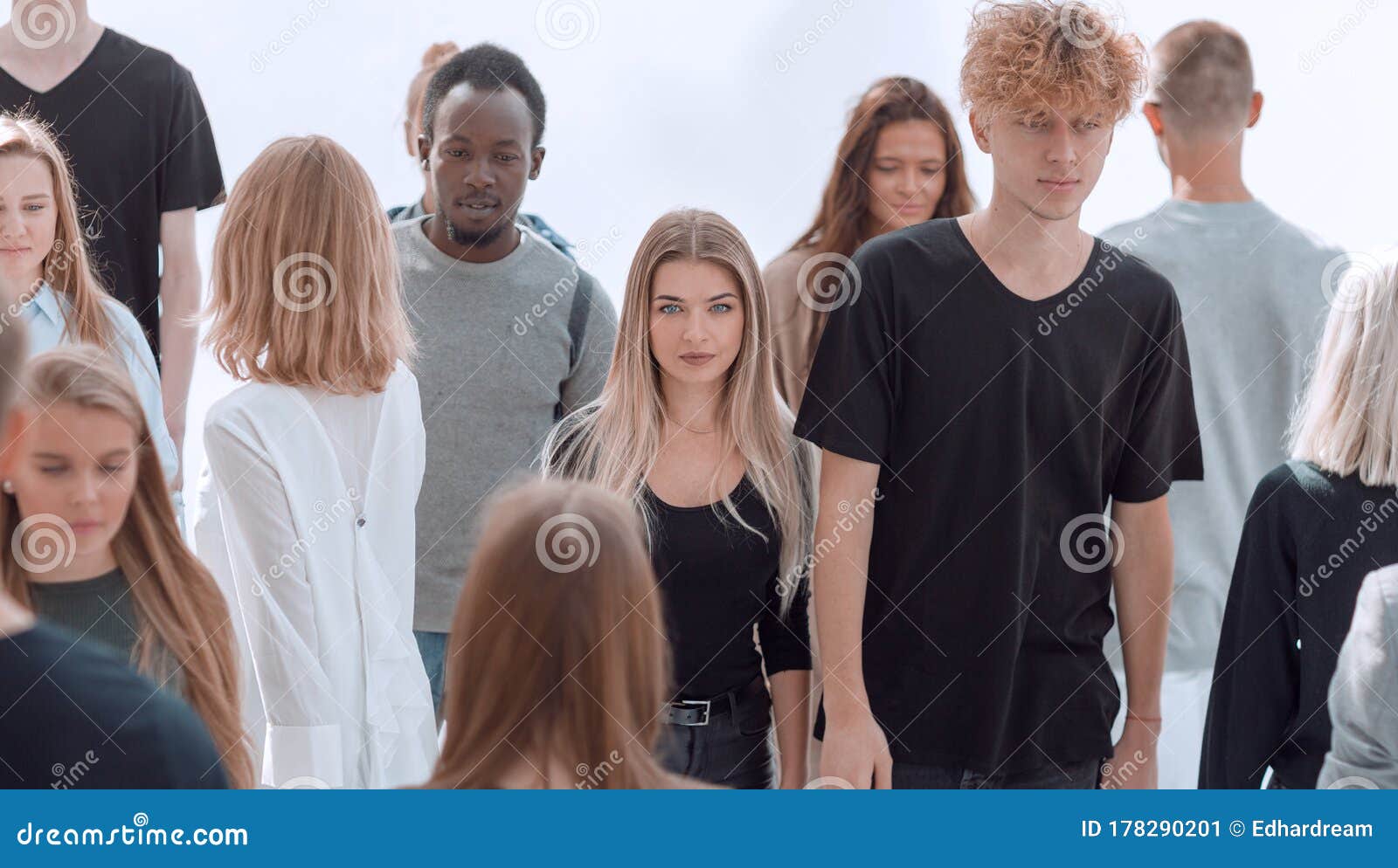 Serious Woman Standing in Front of Casual Group of Young People Stock ...
