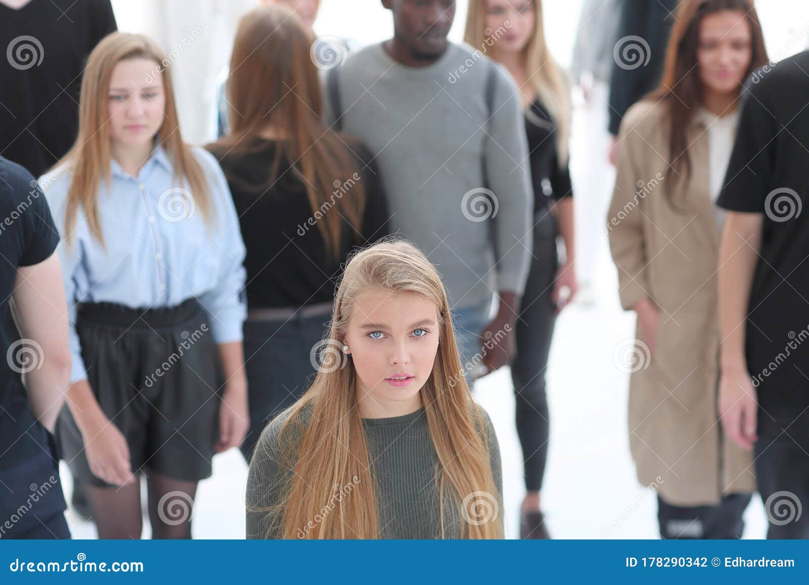Serious Woman Standing in Front of Casual Group of Young People Stock ...