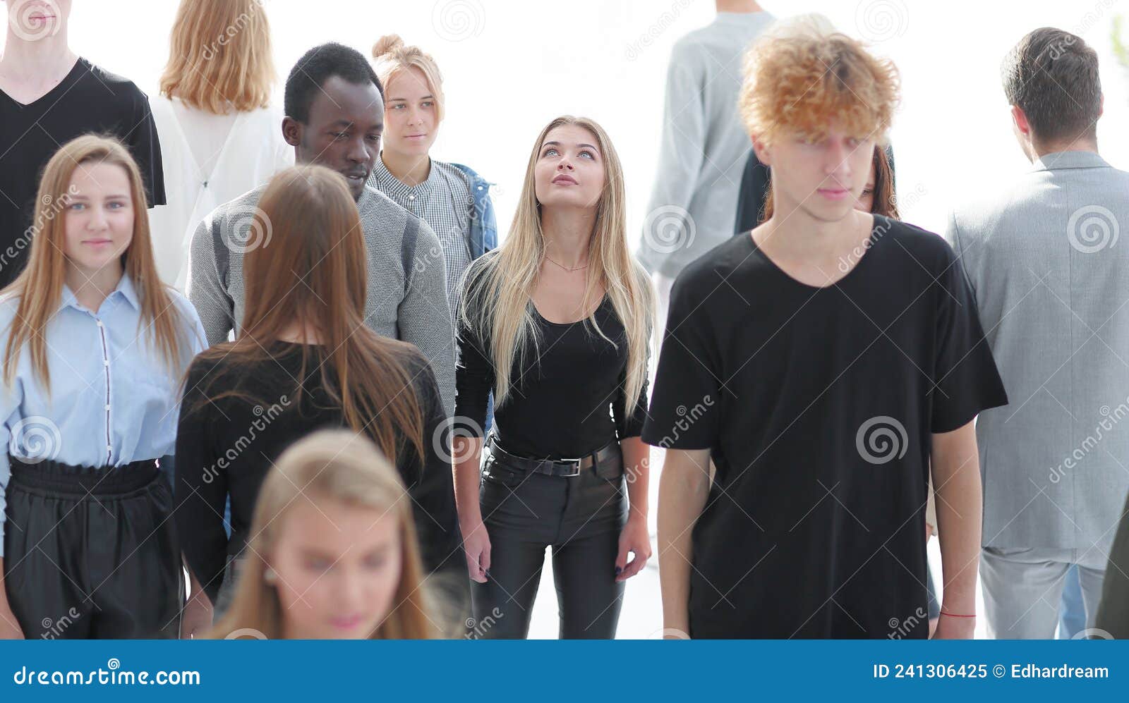 Serious Woman Standing in Front of Casual Group of Young People Stock ...