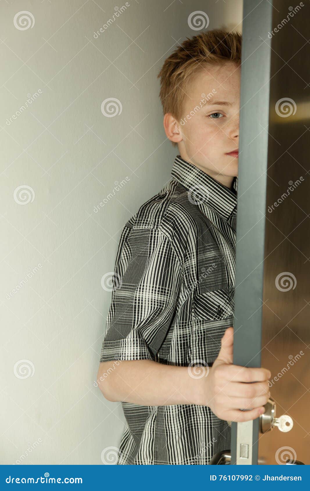 Serious Young Boy Peering Around a Door Stock Photo - Image of serious ...