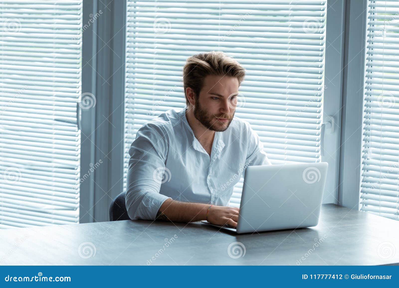 Serious Young Businessman Working on a Laptop Stock Photo - Image of ...