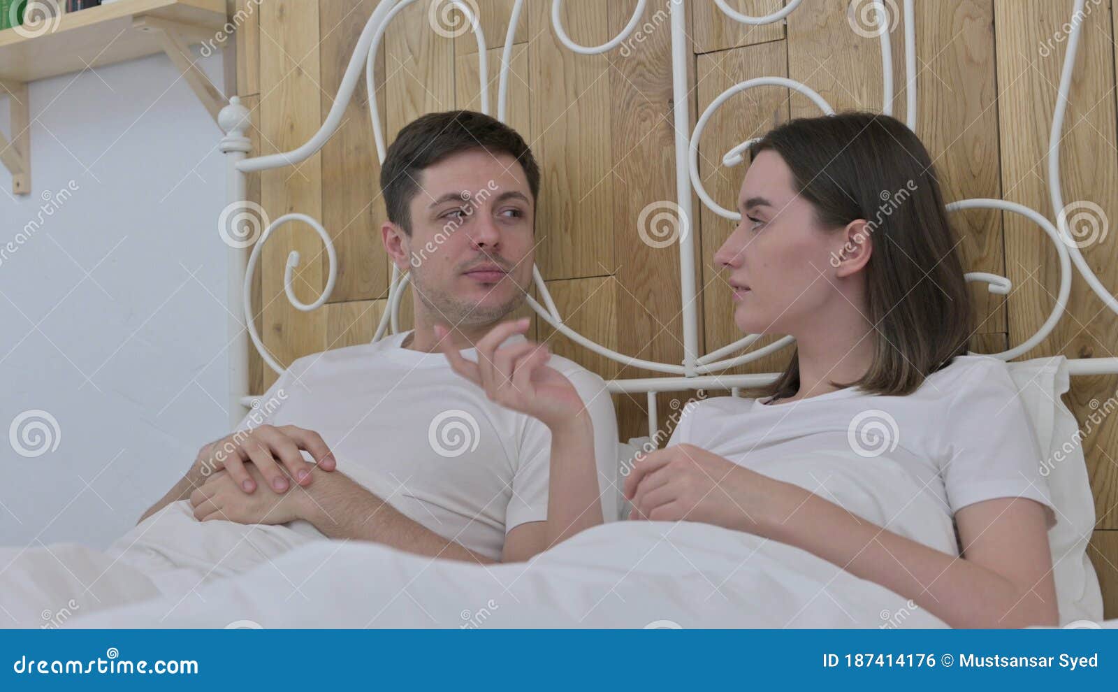 Serious Young Couple Sitting in Bed and Having Conversation Stock Photo ...