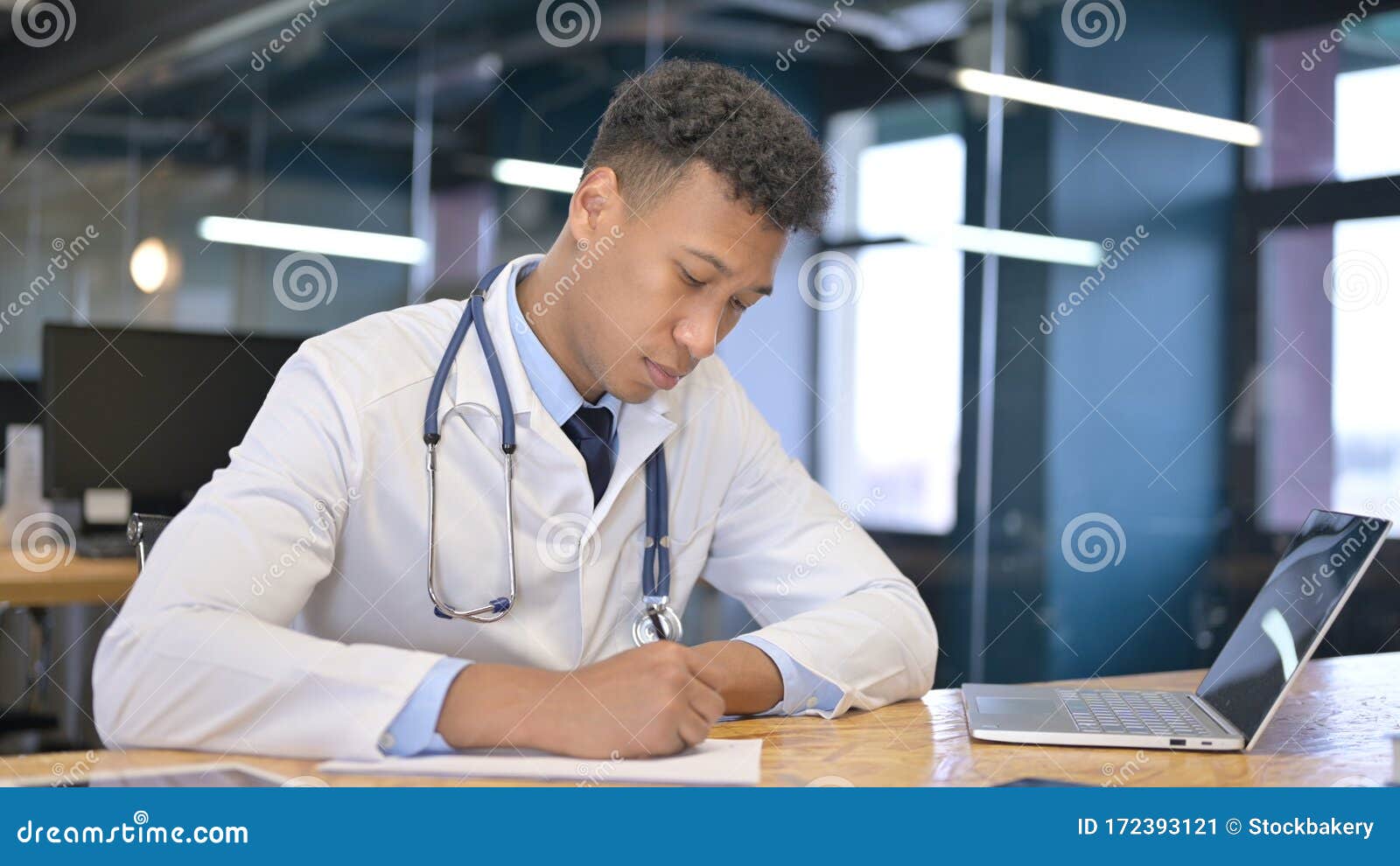 Serious Young Doctor Doing Paperwork in Office Stock Image - Image of ...