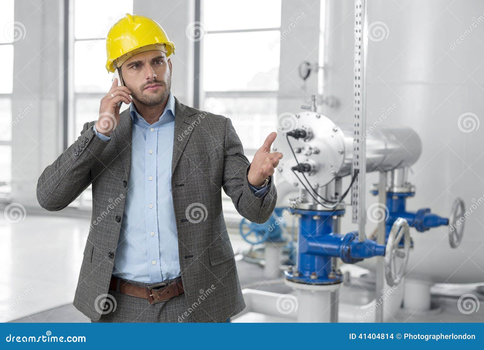 Serious Young Male Manager Using Cell Phone in Industry Stock Photo ...